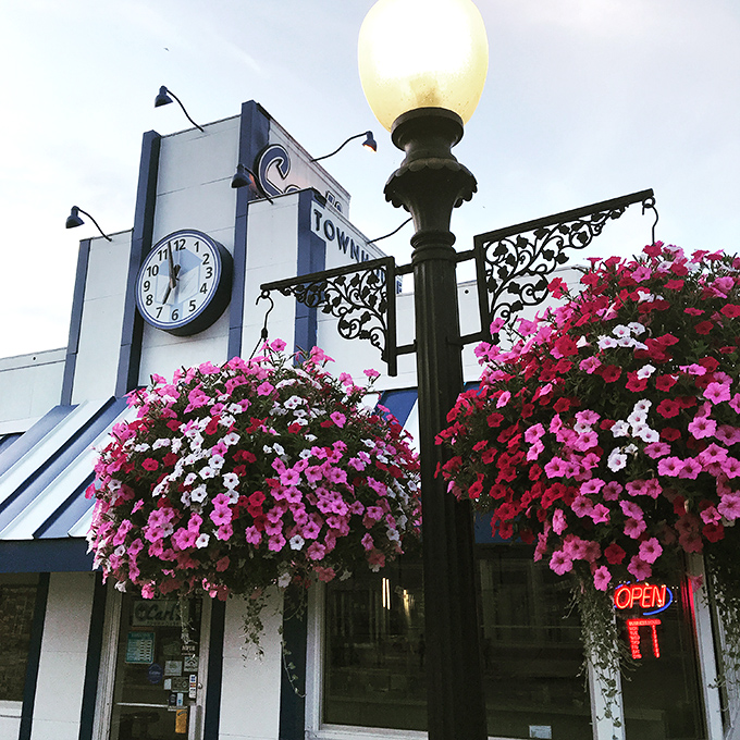 Hanging flower baskets frame the entrance like a colorful welcome committee, adding a touch of beauty that says "we care about the details" before you even taste the food.