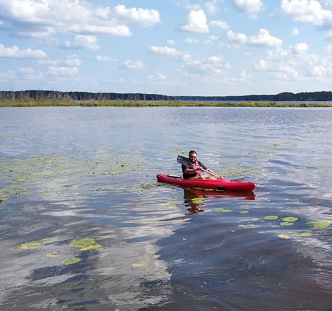 Gliding across mirror-like waters, this solo paddler discovers the lake's secrets while creating ripples that quickly surrender to stillness.