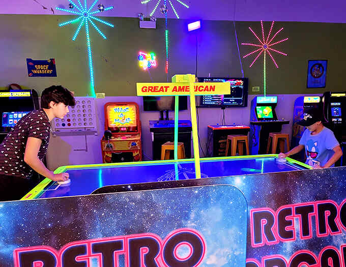Friendly competition at the air hockey table, where glowing pucks zip across the galaxy of the tabletop like comets on a mission.