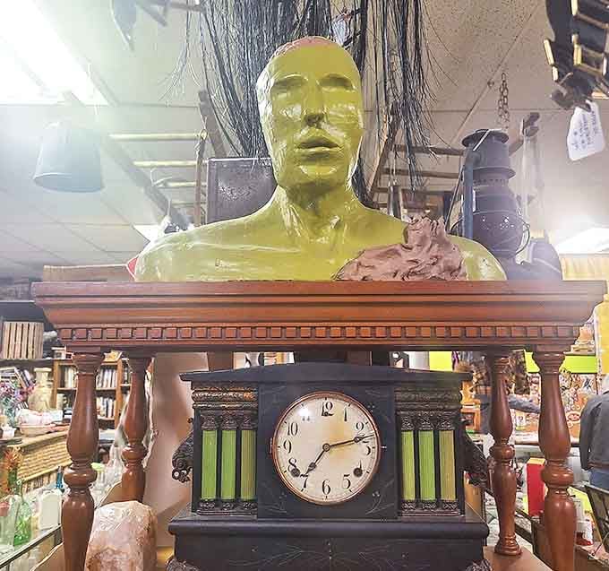 The lime-green bust atop an antique clock creates a timepiece that seems to have escaped from a surrealist painting into Captain Bizzaro's eclectic collection.