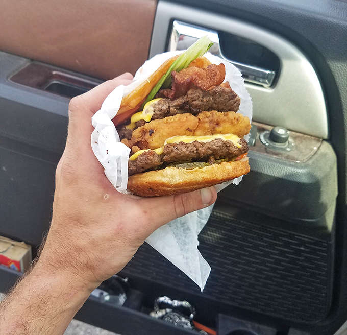 A burger so loaded it requires strategic planning just to take the first bite without losing half the toppings.
