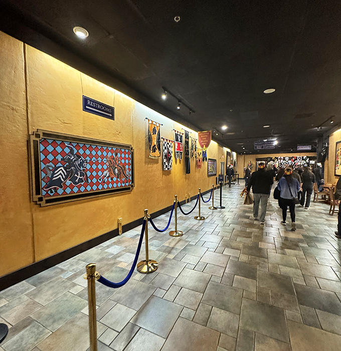 Medieval wall decorations and heraldic shields line the entrance, setting the tone before you've even found your seat or chosen your champion.