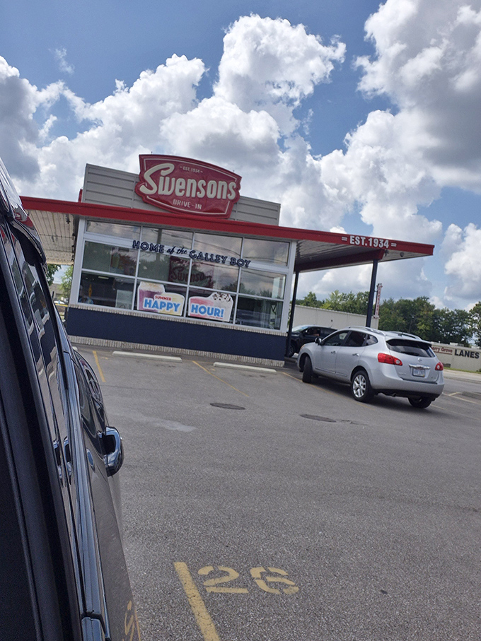 The bustling parking lot at dusk shows Swensons' enduring popularity, with cars filling spaces and headlights signaling hungry patrons ready for their burger fix.