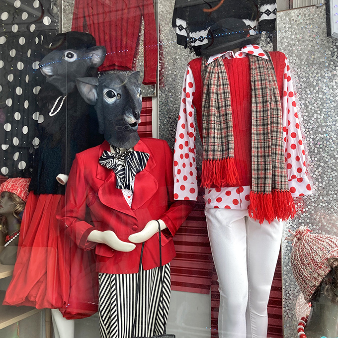 The window display features mannequins with animal heads dressed in coordinated red ensembles &ndash; fashion with a side of delightful surrealism.