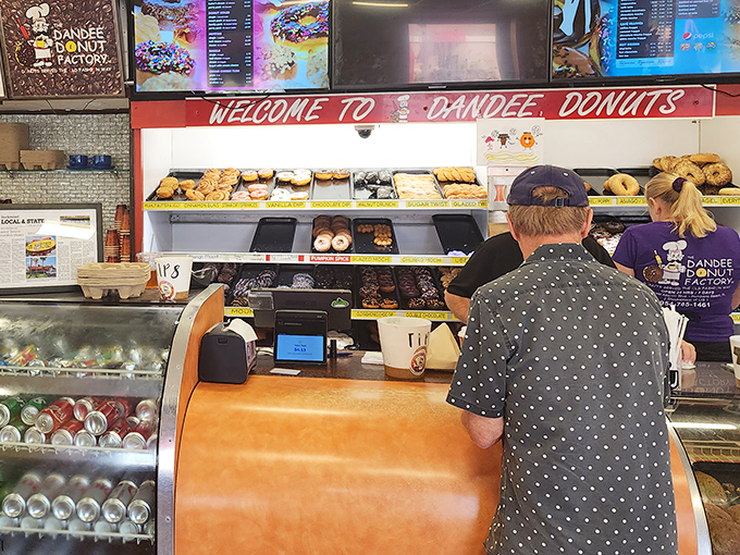 The donut display case – a glass-fronted museum of pastry possibilities that makes decision-making deliciously difficult.