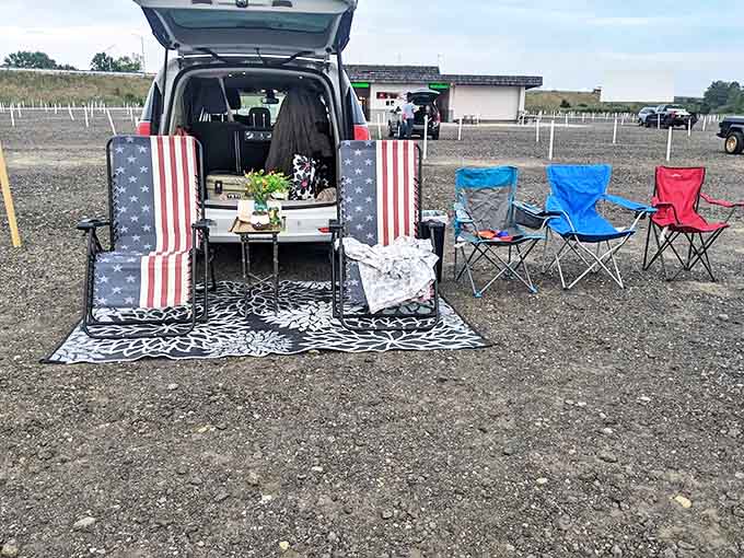 A patriotic tailgate setup transforms movie night into an outdoor living room, complete with comfortable chairs and American flag decor.