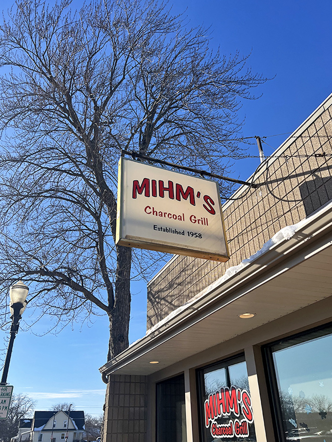 The iconic Mihm's sign stands as a beacon for burger lovers, promising charcoal-grilled perfection beneath clear Wisconsin skies.