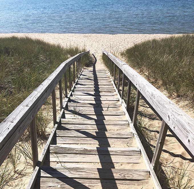 Wooden stairs lead down to the beach like a gateway to paradise, each step bringing you closer to sand, water, and forgetting what day it is.