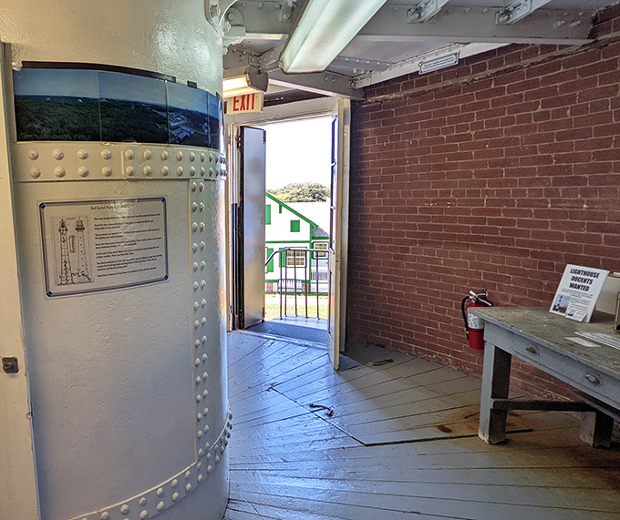 Light streams through the doorway, illuminating the path from maritime history to modern day, with glimpses of the keeper's cottage beyond.