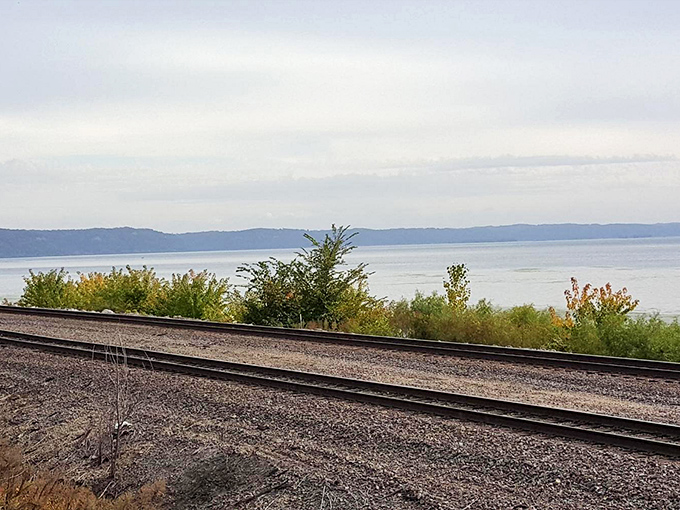 Railroad tracks hug the riverbank, telling stories of commerce and connection that helped build America one rail tie at a time.