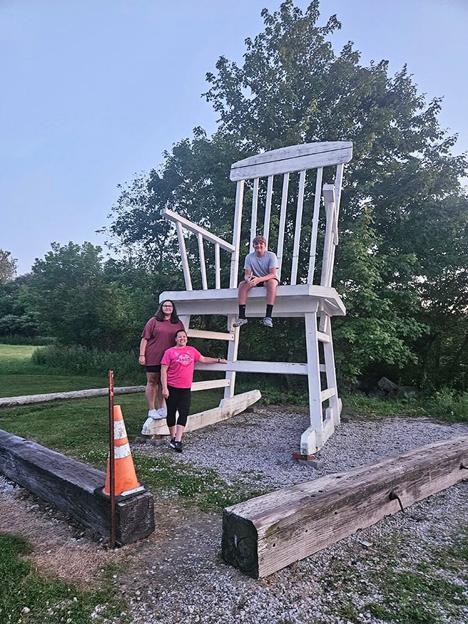 Three explorers demonstrate the chair's massive scale &ndash; what looks like a normal rocker from a distance reveals its true proportions with human comparison.