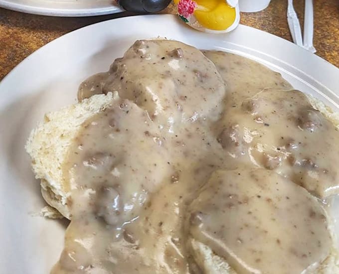 Biscuits swimming in peppery gravy with adorable duck figurines standing guard. Comfort food with a side of whimsy.