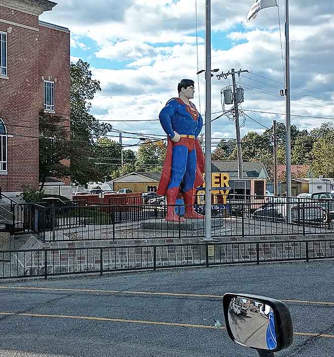 Glimpsed from the road, Superman stands tall against the Metropolis skyline, a beacon for travelers and fans seeking small-town superhero charm.