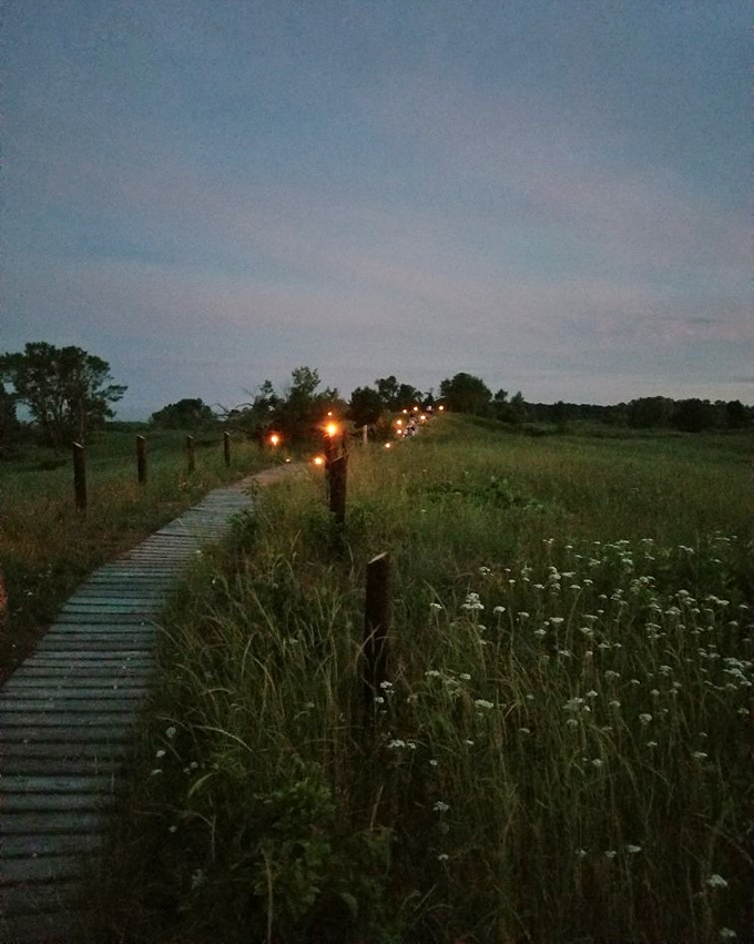 Twilight brings a special magic to the boardwalk, with lanterns guiding the way through deepening shadows.