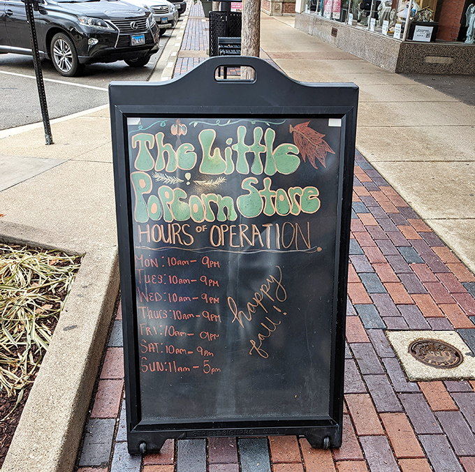 The chalkboard hours sign stands sentinel outside, its handwritten charm promising sweet adventures for anyone willing to squeeze through that famous red door.