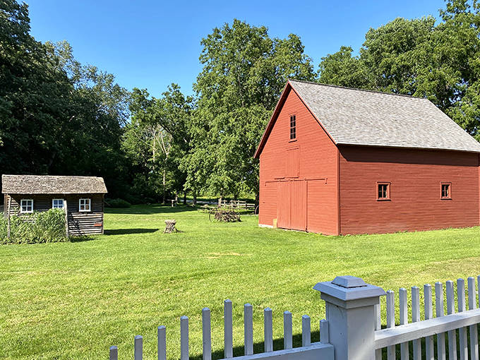 The vibrant red barn stands in sharp contrast to the lush green landscape, like a real-life version of your childhood farm toy set.