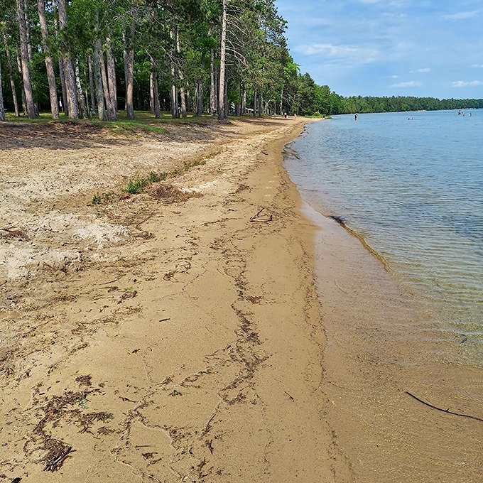 The gentle meeting of land and water creates rippling patterns in the sand, nature's own temporary artwork refreshed with each wave.