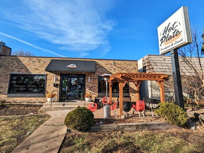 The outdoor setting welcomes guests with simple charm and that iconic sign. Morning sunshine makes the brick exterior glow like a beacon for breakfast seekers.