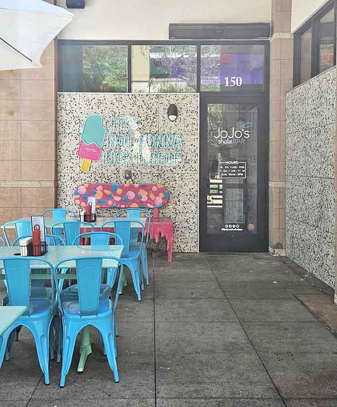 The outdoor seating area features turquoise chairs and a wall declaring "Life's Not Gonna Lick Itself" &ndash; subtle, they are not.