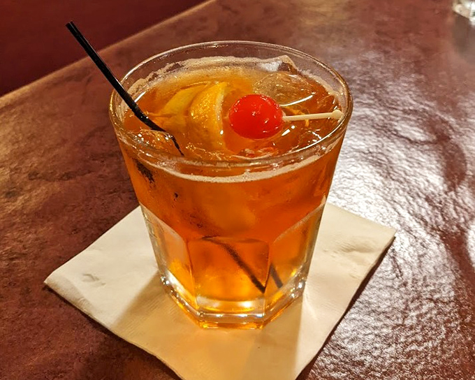 An amber Manhattan garnished with cherry and orange &ndash; mixed with confidence by bartenders who don't need to consult recipes.