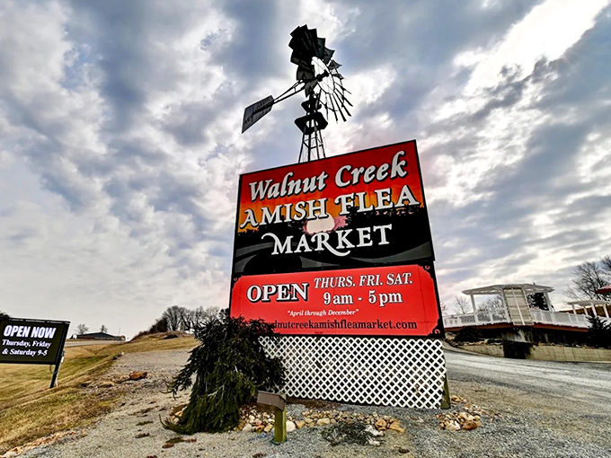 The iconic Walnut Creek Amish Flea Market sign welcomes visitors with its distinctive windmill &ndash; a beacon for treasure hunters.