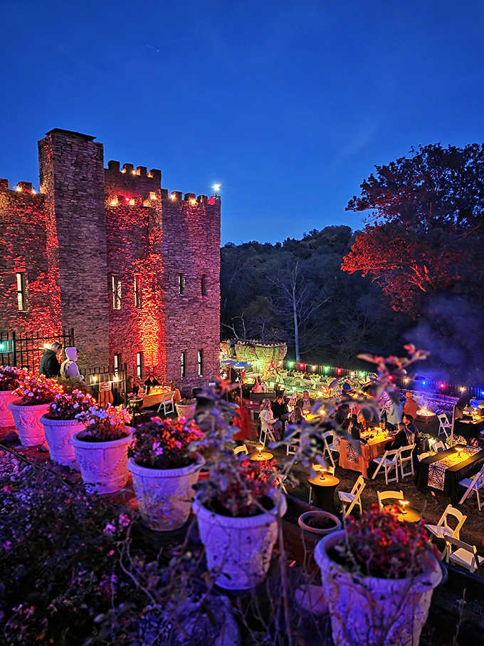 By night, Loveland Castle transforms into a magical illuminated wonderland, its stone walls glowing with warmth against the darkness.