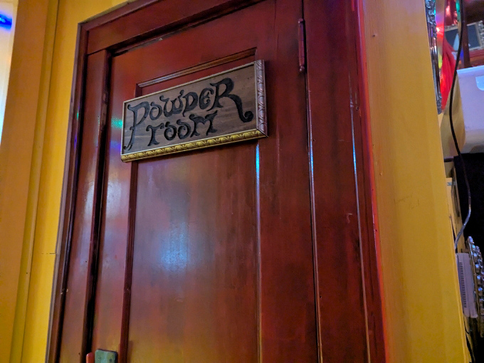 The "Powder Room" sign adds a touch of vintage class. In a hot dog museum, even the restroom entrance maintains the old-school burlesque theme.