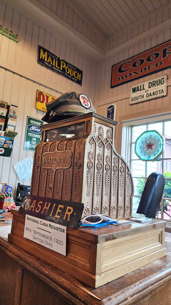 The ornate 1920 National cash register represents commerce before digital displays, its mechanical keys and brass details announcing each sale with authoritative clicks and dings.
