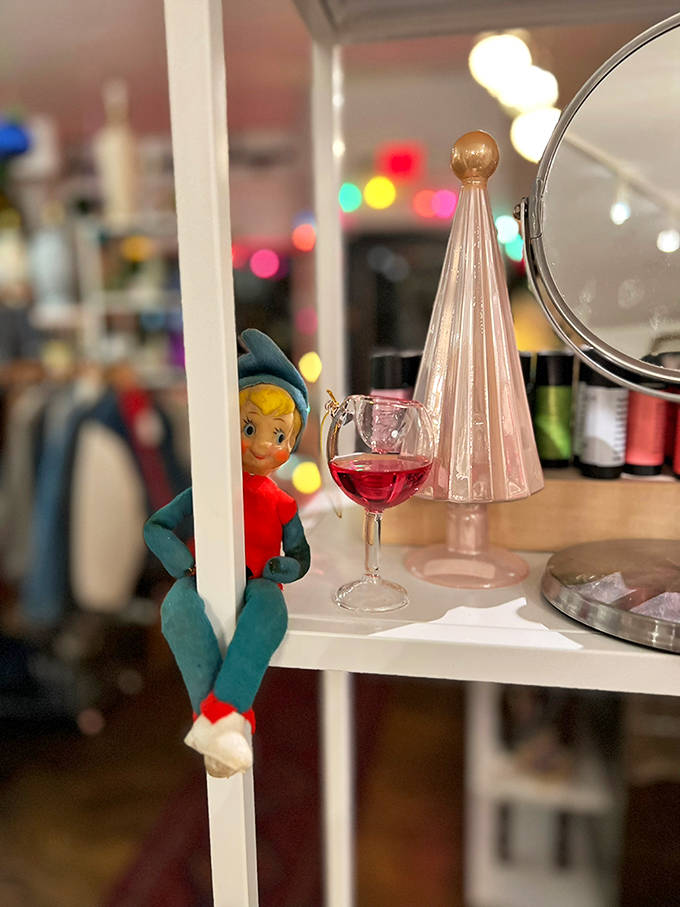 A vintage pixie elf shares shelf space with mid-century glassware, because the best vintage shops embrace the whimsical alongside the sophisticated without apology.