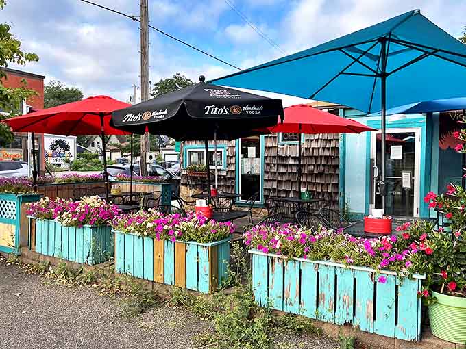 The patio offers a tropical escape during Minnesota summers, complete with colorful umbrellas and flower-filled planters.