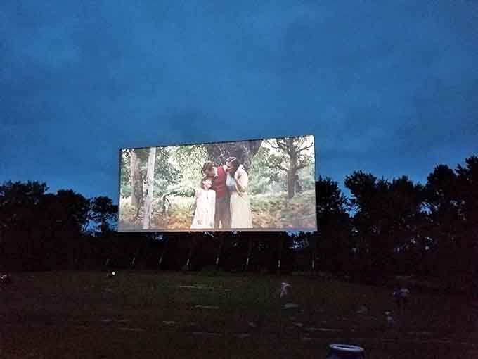 As darkness envelops the countryside, the illuminated screen becomes the center of a shared experience that transcends individual viewing.