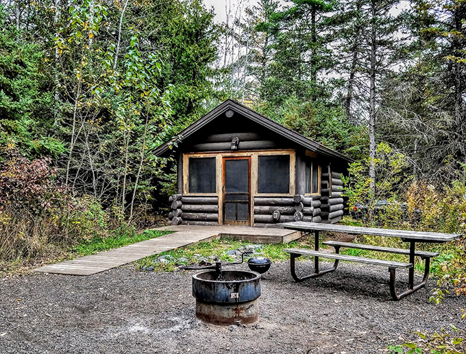 A rustic log cabin offers shelter for overnight adventurers seeking to extend their wilderness experience.