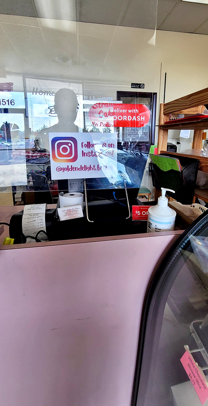 Behind the counter magic happens daily, with signs for social media and delivery options bringing this beloved bakery into the digital age.