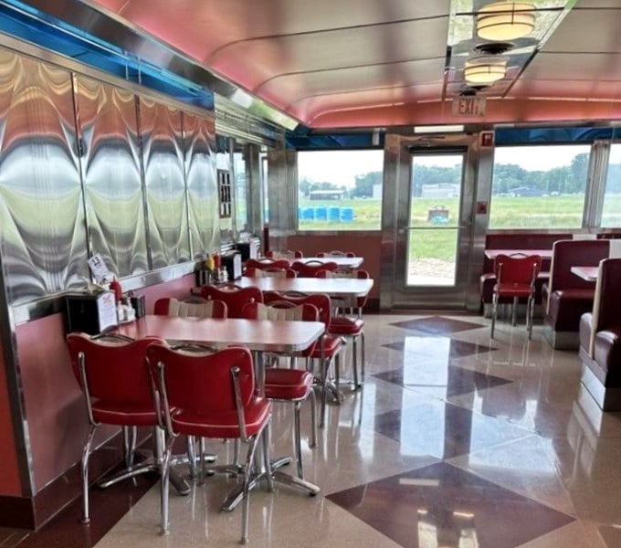 Sunlight streams through large windows, offering glimpses of the airfield beyond – a perfect marriage of dining and aviation history.
