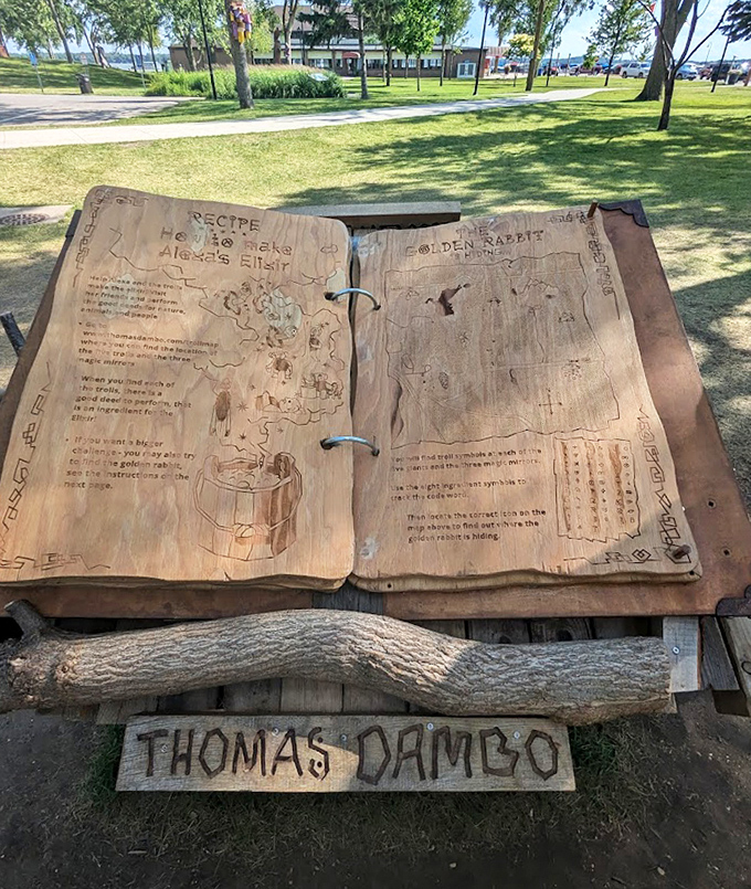 The secret recipes of trolls, carved into an enormous wooden spellbook. Thomas Dambo's signature marks this magical tome that guides visitors through the enchanted scavenger hunt.