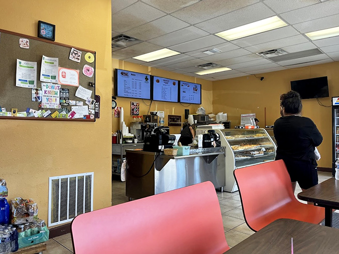 The cozy interior invites customers to linger over coffee and donuts, where fluorescent lights spotlight the real stars of the show.