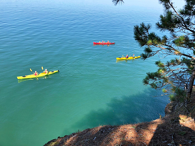 Colorful kayaks dot the turquoise waters below, offering adventurers the sea-level perspective that completes the Meyers Beach experience.