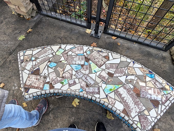 This artistic mosaic bench invites visitors to rest while appreciating local history through embedded photographs and colorful designs.