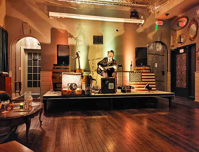 The stage comes alive &ndash; A musician shares soulful melodies against a backdrop of warm wood tones and vintage Americana, creating an atmosphere of nostalgic comfort.
