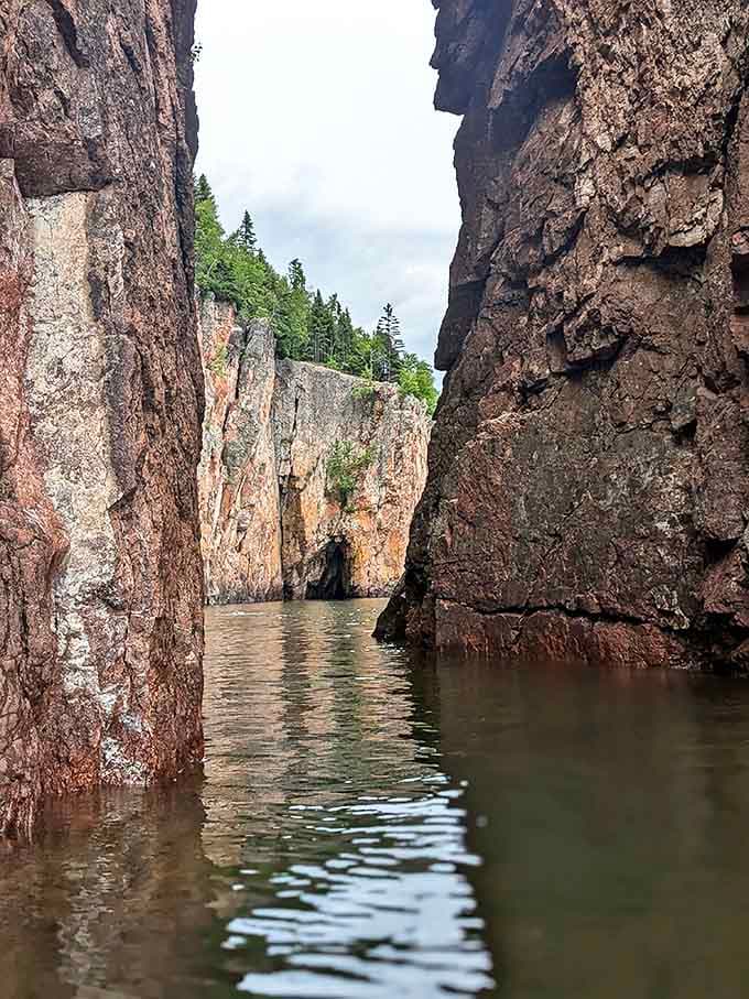 Hidden sea caves carved by millennia of Lake Superior's persistent waves create mysterious passages beneath Palisade Head's towering cliffs.