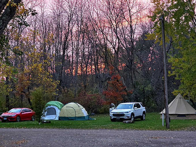 As day surrenders to dusk, colorful tents become beacons of comfort against a backdrop of nature's most spectacular light show.