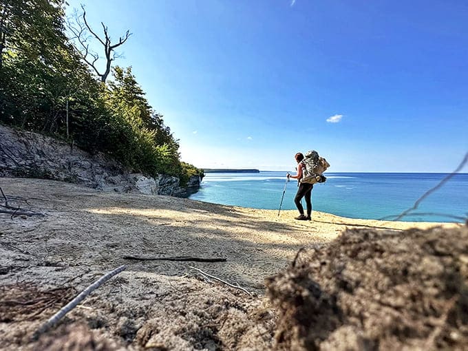 A solitary explorer pauses to absorb Lake Superior's vastness, finding that perfect moment of connection between human and wilderness.