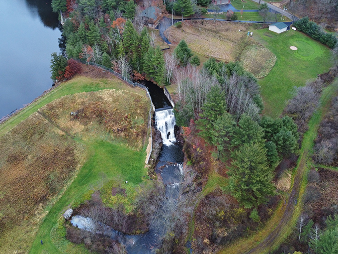 From above, the waterfall reveals its perfect placement – nature's architectural masterpiece nestled between forest and field.