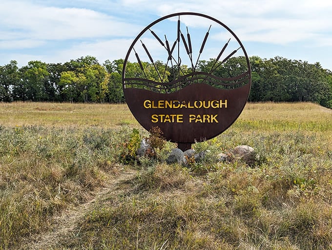 Glendalough's entrance sign stands proudly amid prairie grasses, a metal sentinel guarding one of Minnesota's best-kept natural secrets from overcrowding.