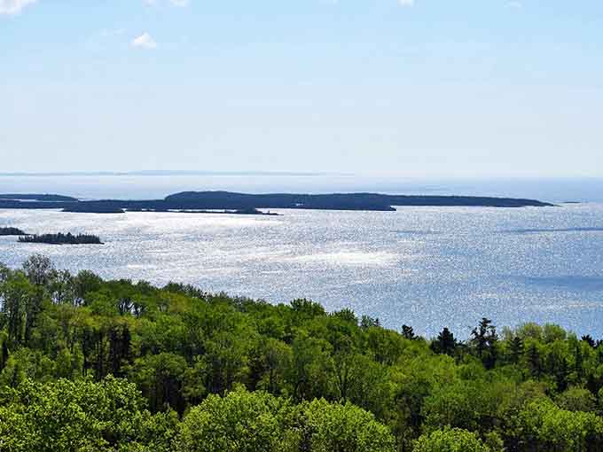 The shoreline that launched a thousand ships and inspired countless road trips. Lake Superior's edge beckons from far below.