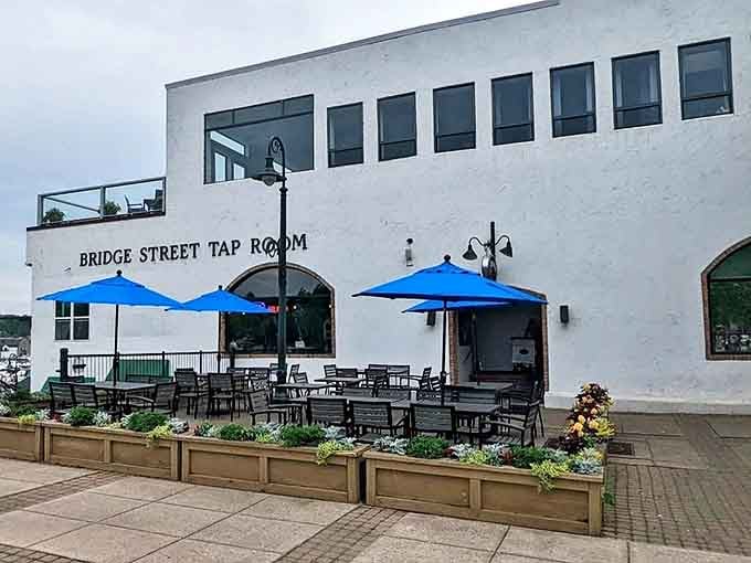 The white-washed exterior with its blue umbrellas and waterfront setting creates a postcard-perfect Michigan scene that practically begs you to stay awhile longer.