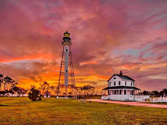 Sunset transforms the lighthouse into a silhouette against skies painted in colors that make you understand why people write songs about moments like this.