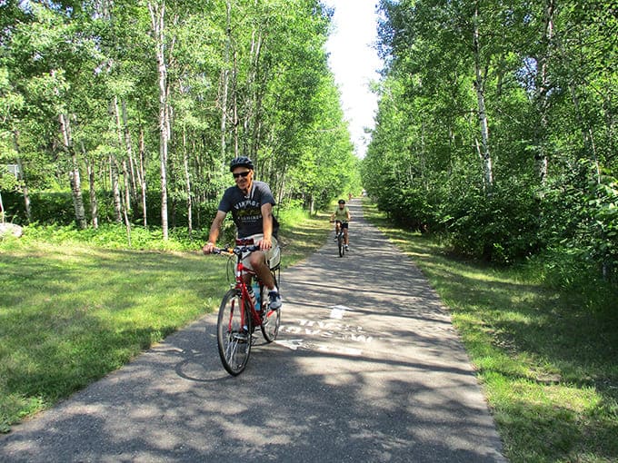 The trail's tree-lined corridor creates a natural cathedral where cyclists can worship at the altar of outdoor recreation, surrounded by Minnesota's finest greenery.