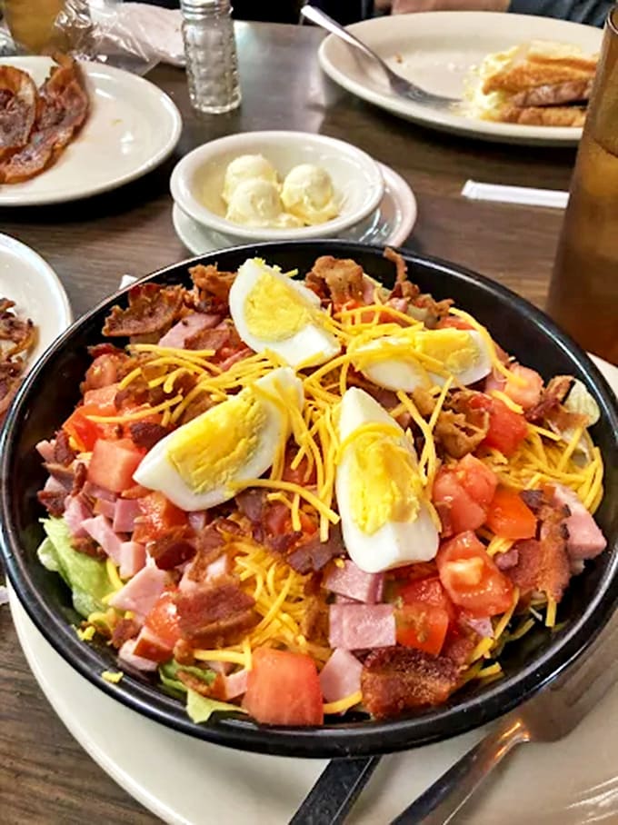 A Cobb salad engineered like a skyscraper, with layers of ingredients that somehow taste even better than they look.