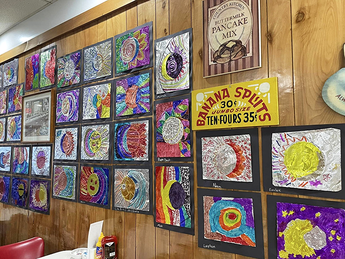 Local children's artwork decorates the walls, creating a colorful gallery that celebrates community alongside vintage diner memorabilia.
